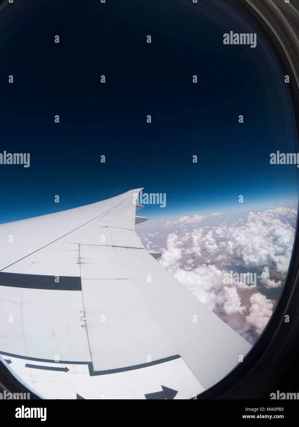 Plane’s wing and clouds over the land view from a planes window Stock ...