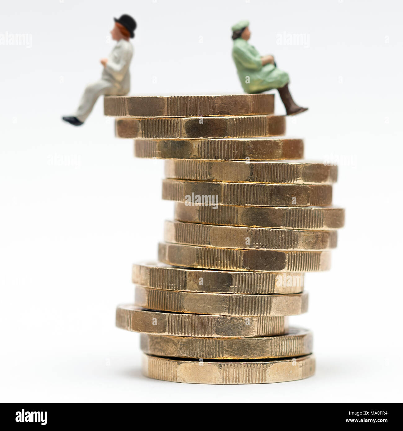 Gender pay equality concept image of man and woman on a stack of pound ...