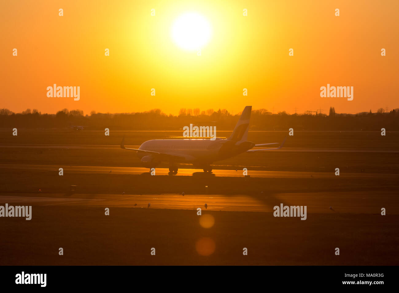 passenger airplane on an airport runway in an evening sundown Stock ...