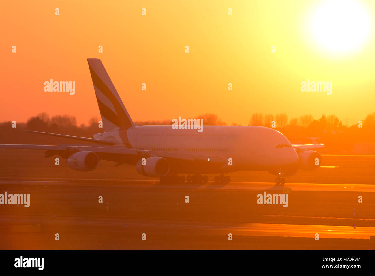 passenger airplane on an airport runway in an evening sundown Stock ...