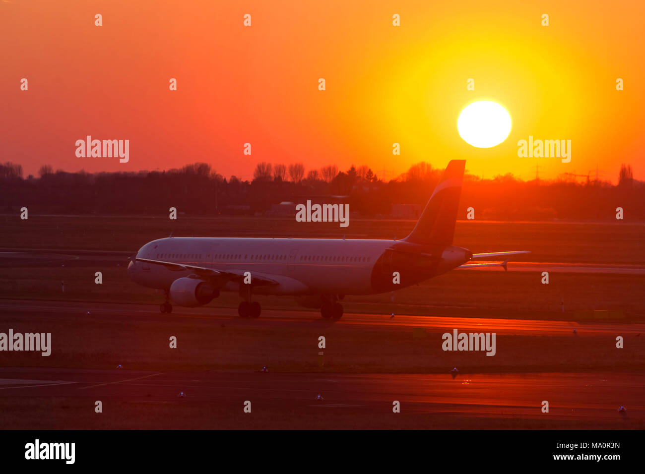 passenger airplane on an airport runway in an evening sundown Stock ...