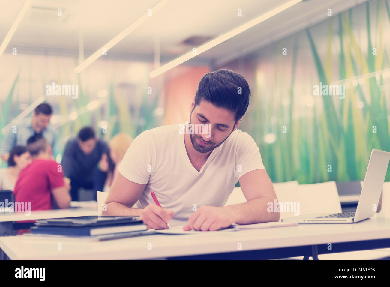 male student in classroom working homework and learning with laptop ...