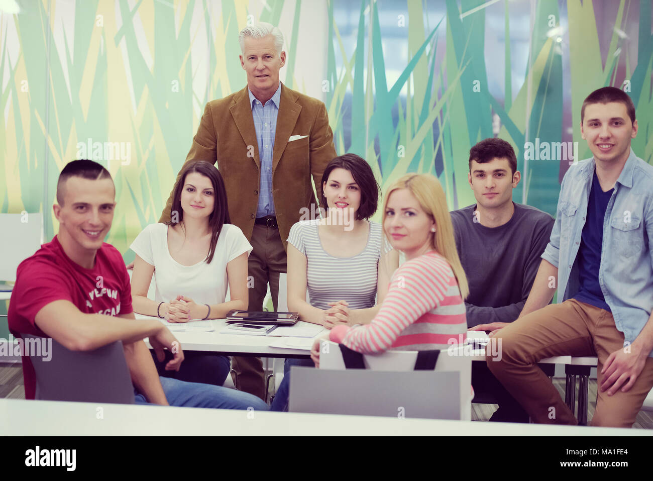 portrait of confident teacher, students group in background Stock Photo ...