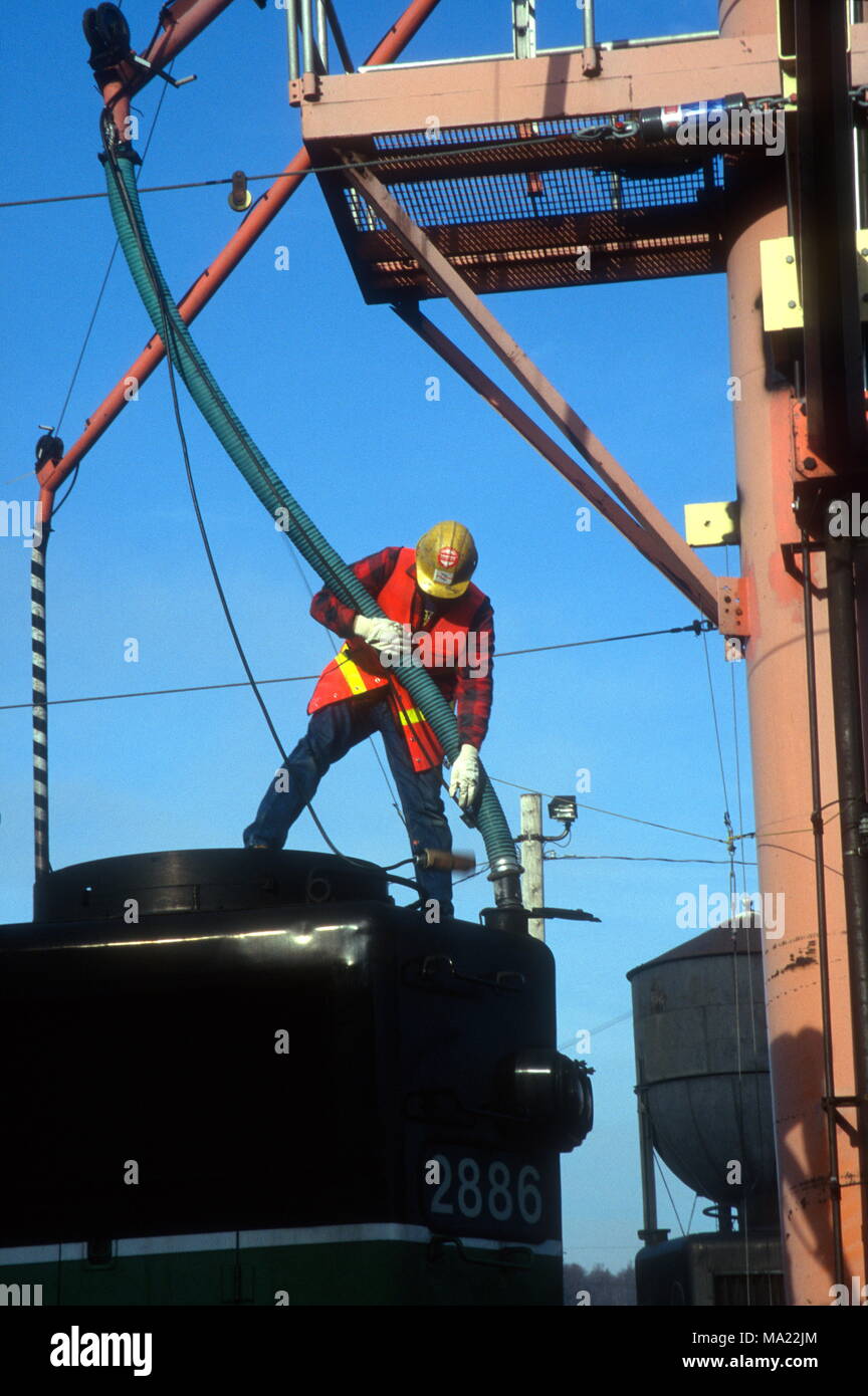 Railroad worker refueling a diesel locomotive at a rail yard in Seattle ...