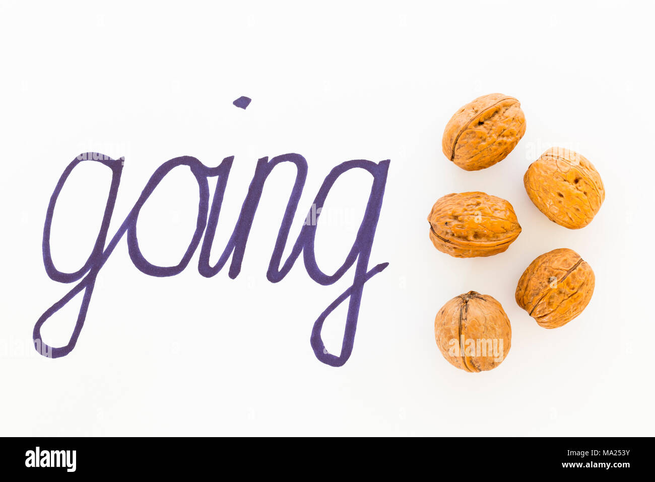 Concept of the phrase going nuts with brown nuts and black ink hand ...