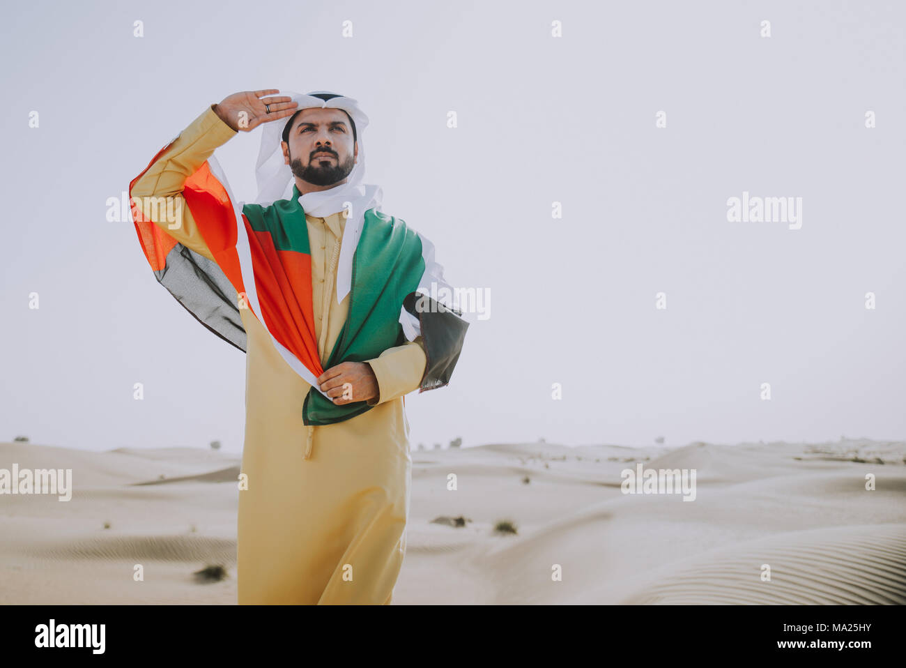 Man wearing traditional uae clothes spending time in the desert Stock ...