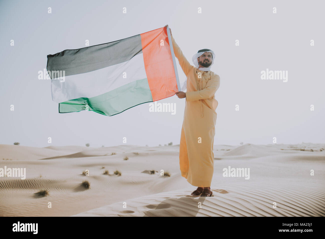 Man wearing traditional uae clothes spending time in the desert Stock ...
