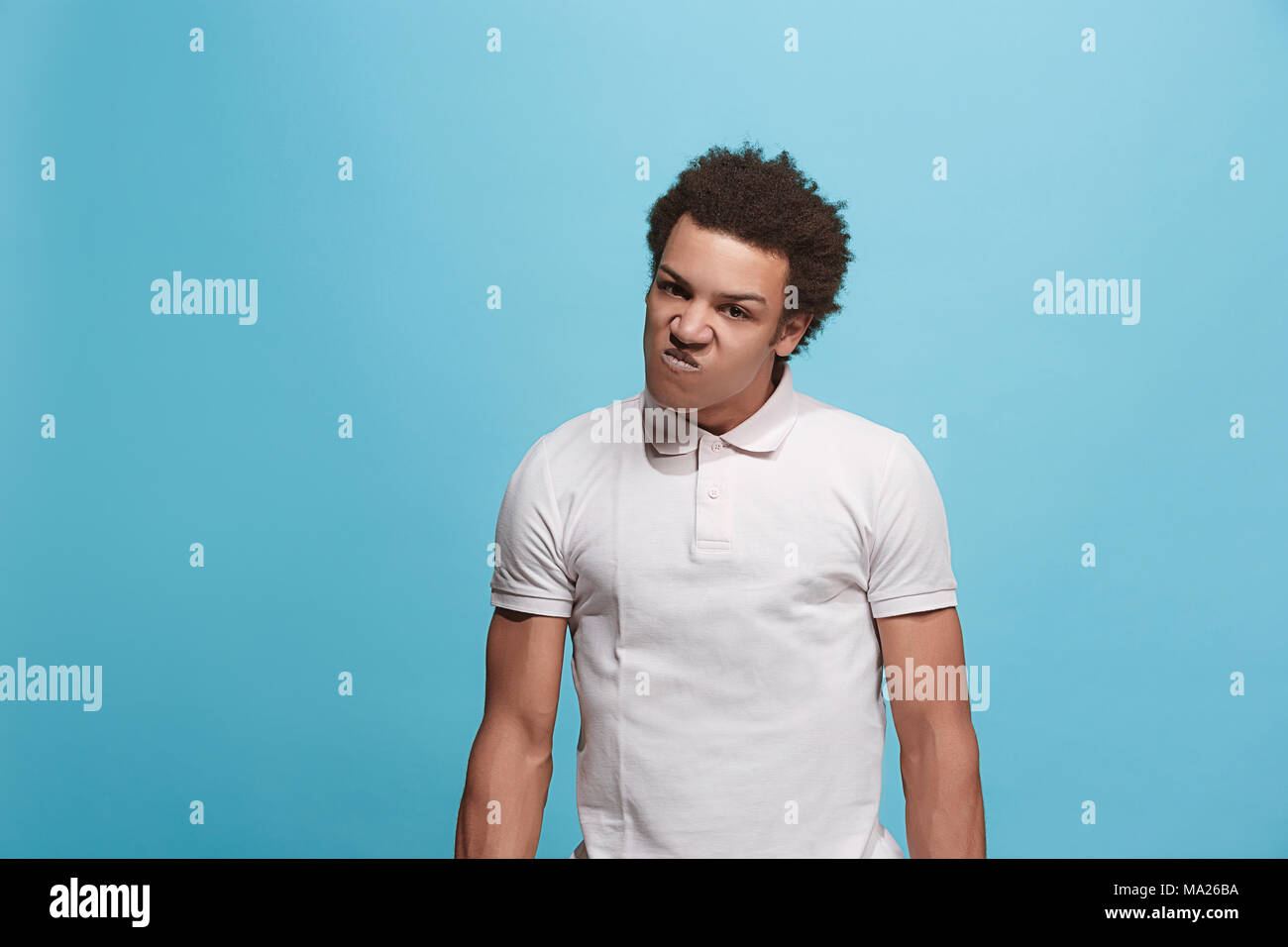 The young emotional angry man screaming on blue studio background Stock ...