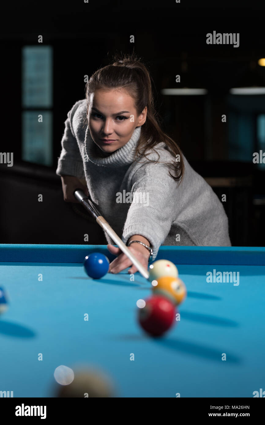 Young Woman Lining To Hit Ball On Pool Table Stock Photo - Alamy