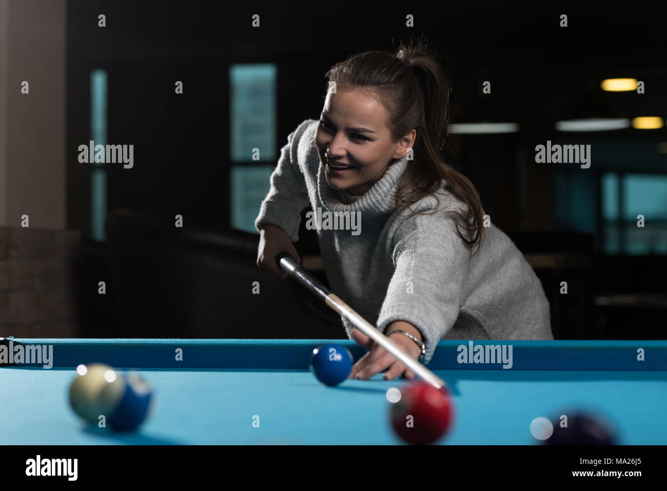 Young Woman Lining To Hit Ball On Pool Table Stock Photo - Alamy