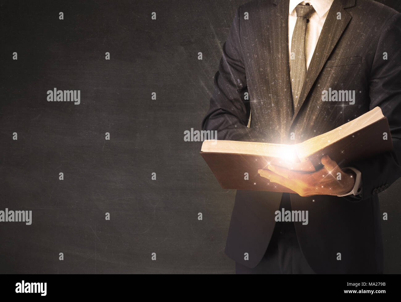 Man holding and reading a shiny book Stock Photo - Alamy