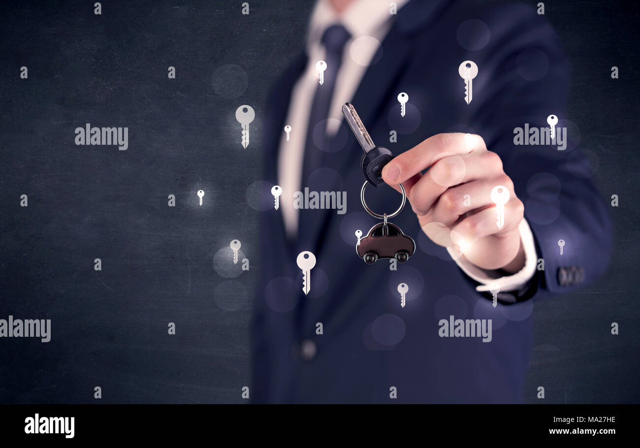 Businessman in suit holding keys with keys graphics around and dark ...