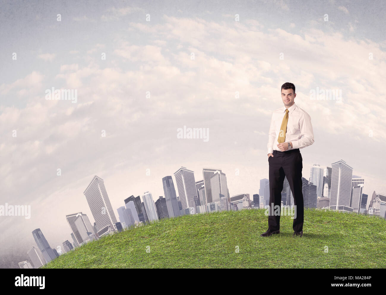 A successful male good looking business man standing in small green ...