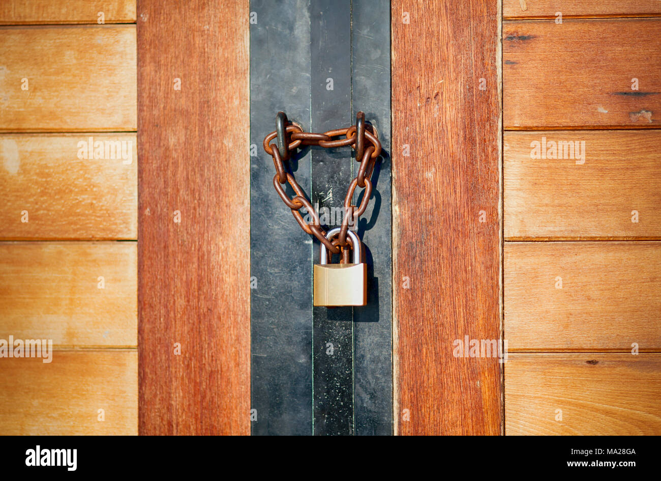 Wooden door closed by chain and padlock. Close-up Stock Photo - Alamy