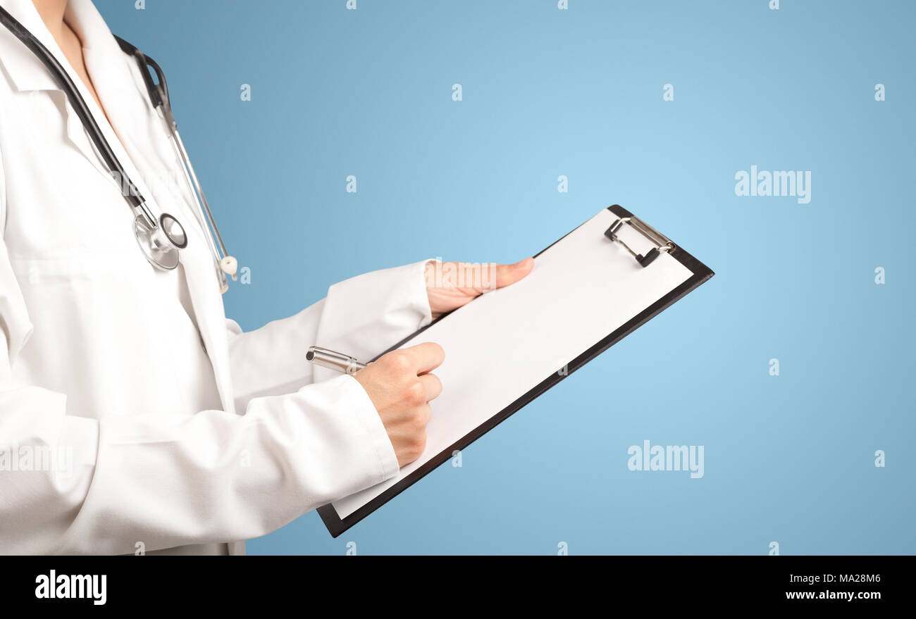 Female doctor holding notepad with blue background Stock Photo - Alamy