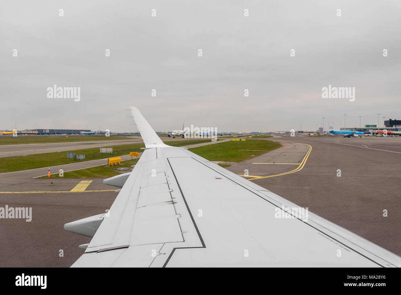A view out of a landed passenger airplane taxiing along a runway ...