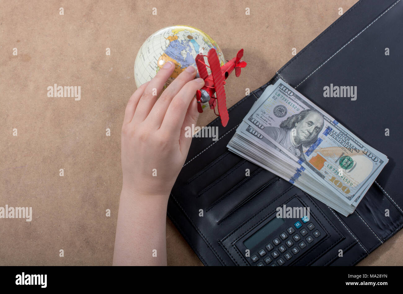 Hand holding model airplane beside globe and American dollars Stock ...