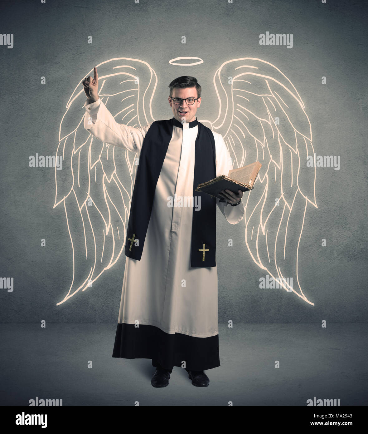 A young male priest with drawn large angel wings standing with the holy ...