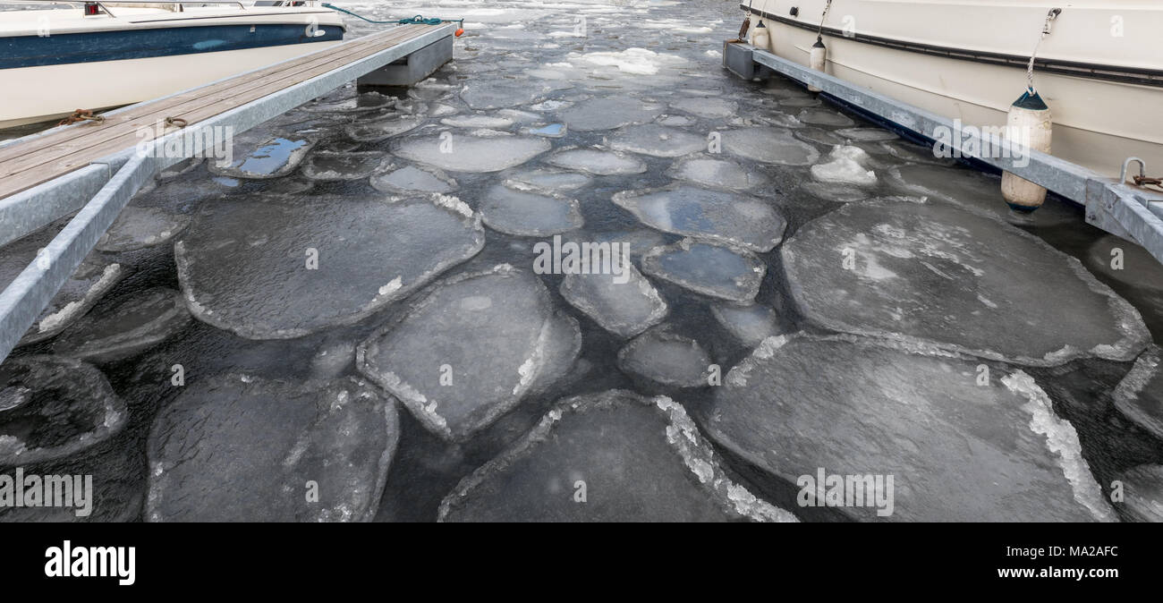 Ice floating in the water at the harbour, the pier for small boats ...