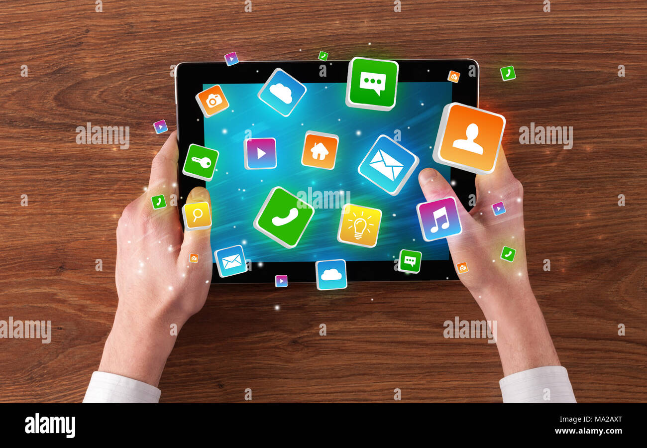 Hand using tablet with colourfull bounce application symbols and icons ...