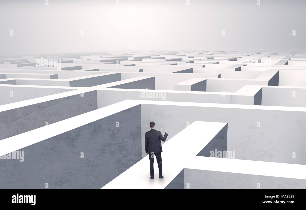 Small businessman in a middle of a huge maze Stock Photo - Alamy
