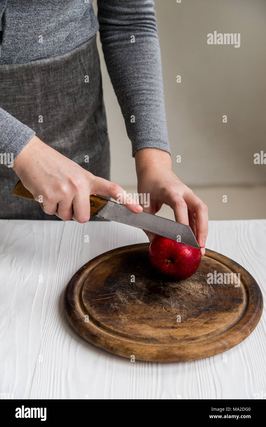 Close up female hands slicing red apple with knife into pieces Stock ...