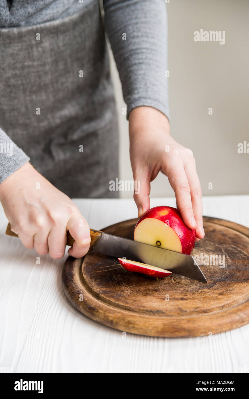 Close up female hands slicing red apple with knife into pieces Stock ...