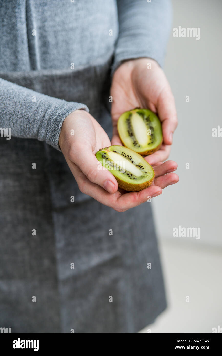 Close up female hands holding fresh sliced kiwi fruit Stock Photo - Alamy