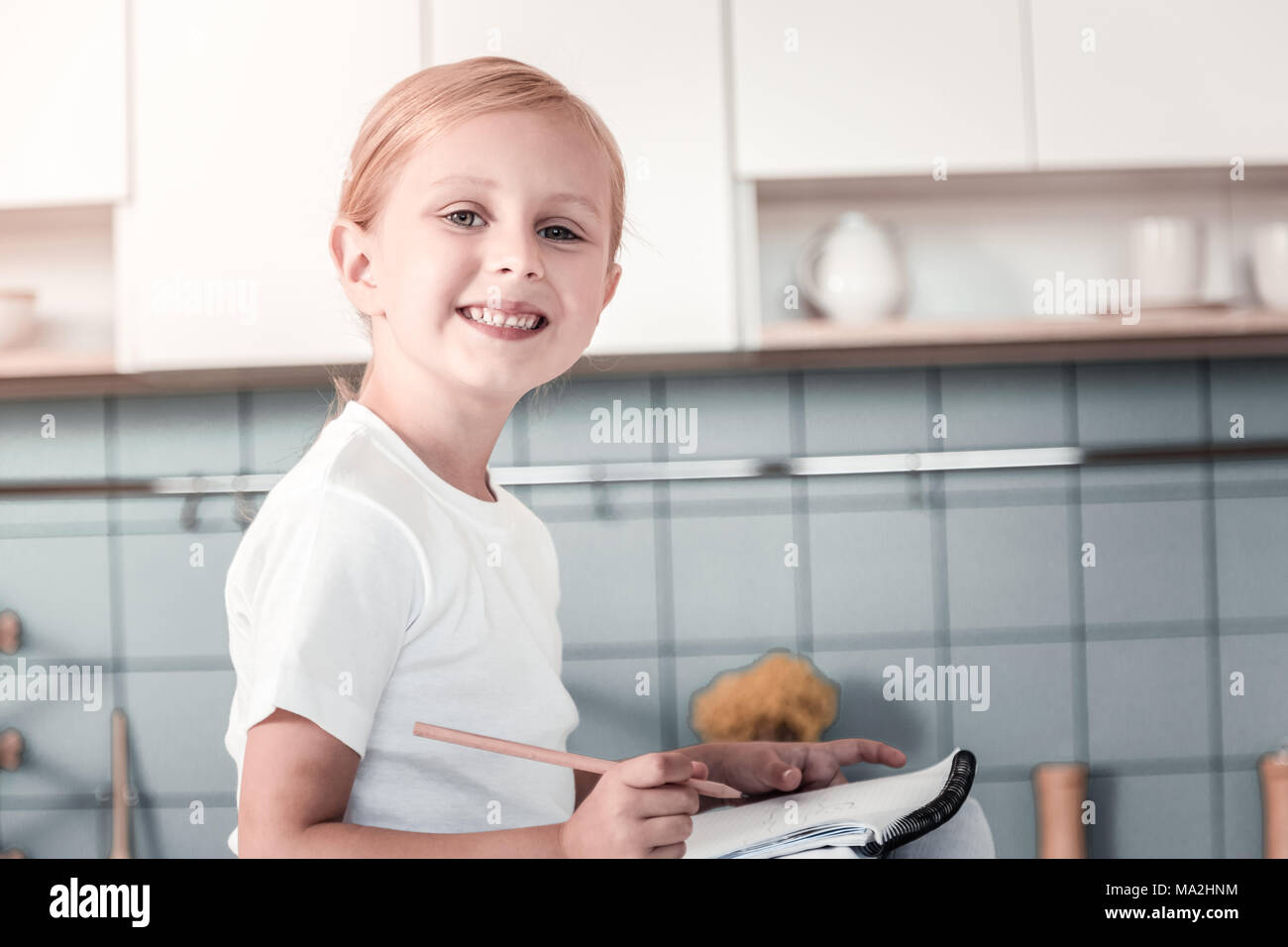 Pleasant smile. Cheerful girl expressing positivity while drawing ...