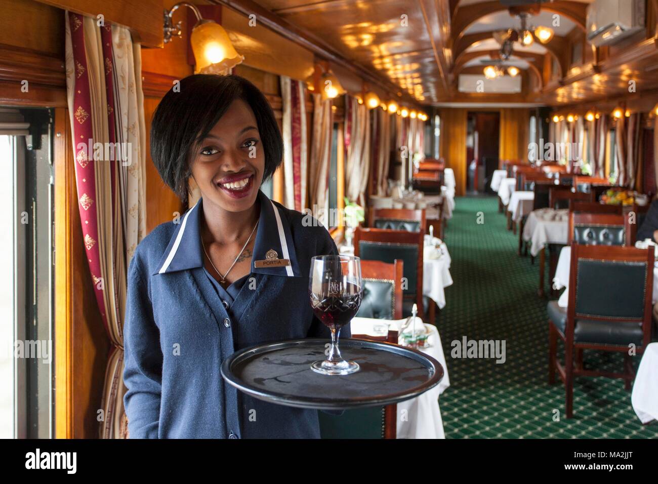 A waitress serving South African wine in the buffet car of the luxury ...