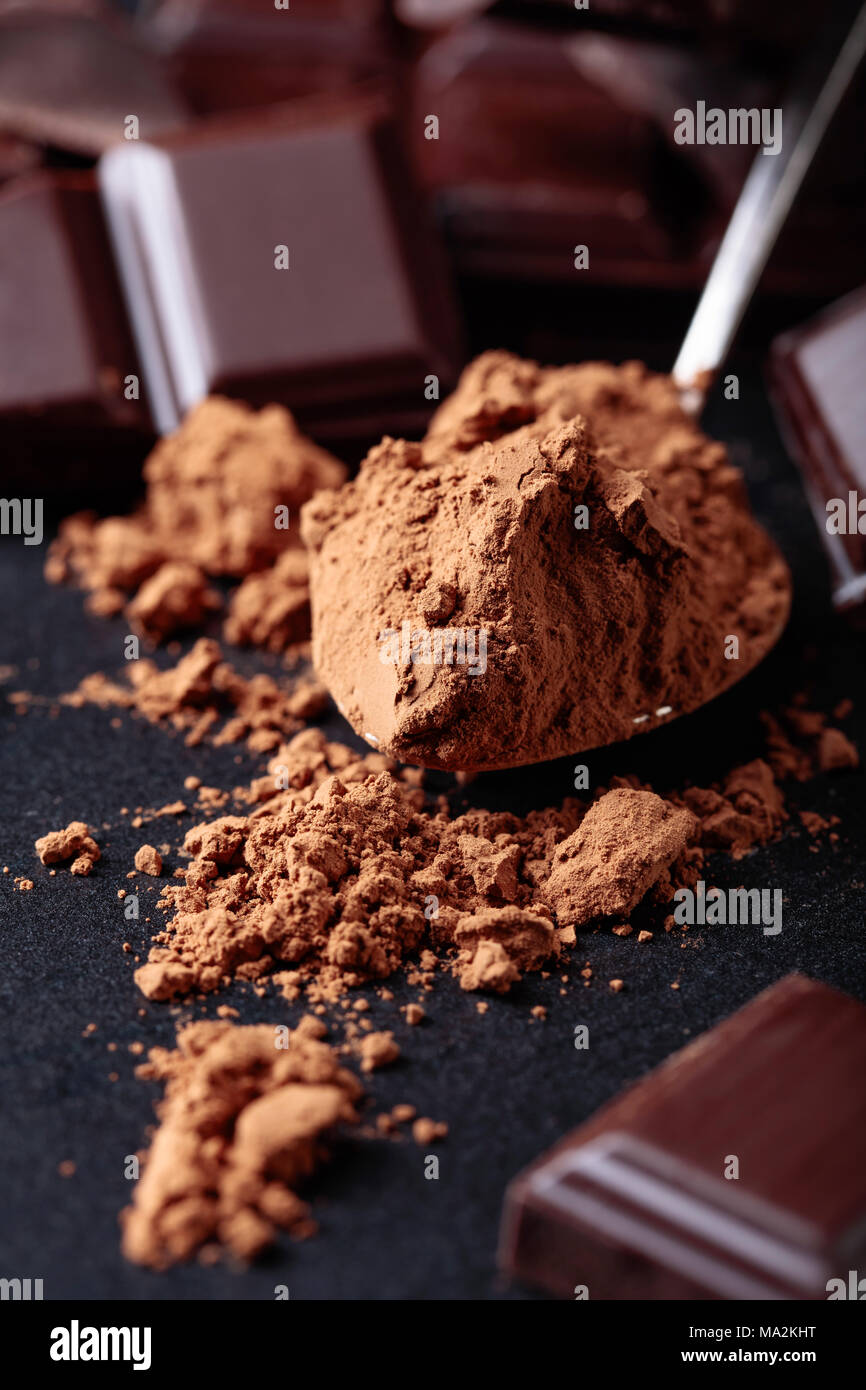Broken chocolate pieces and cocoa powder on black background Stock ...