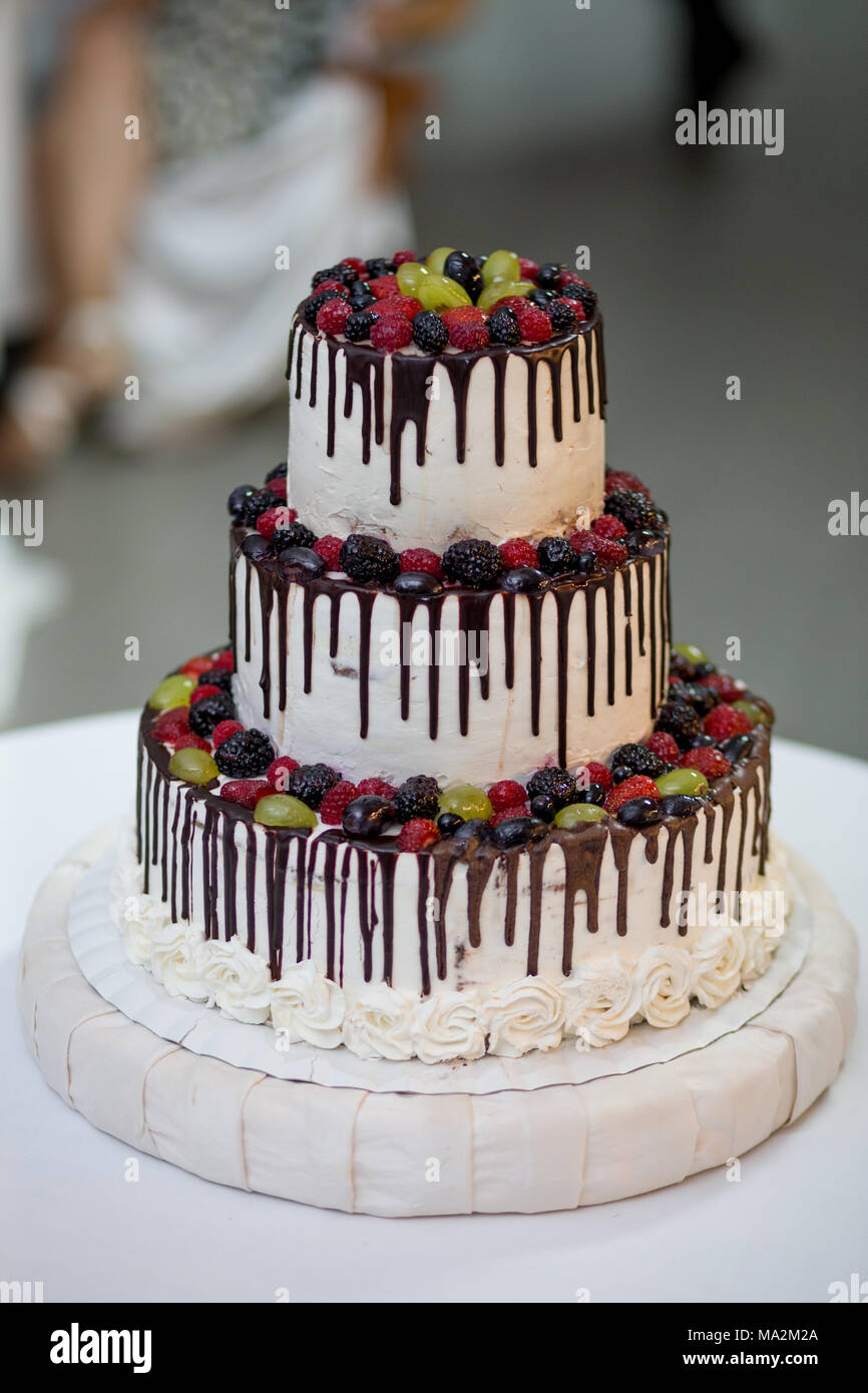 Three-tiered cake with berries Stock Photo - Alamy