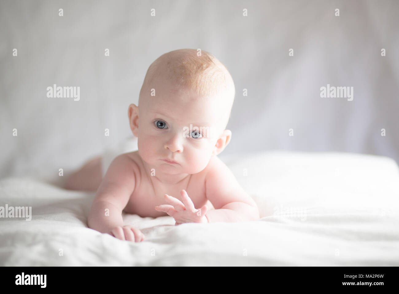 cute baby boy lying on bed with a contemplative look on his face Stock ...