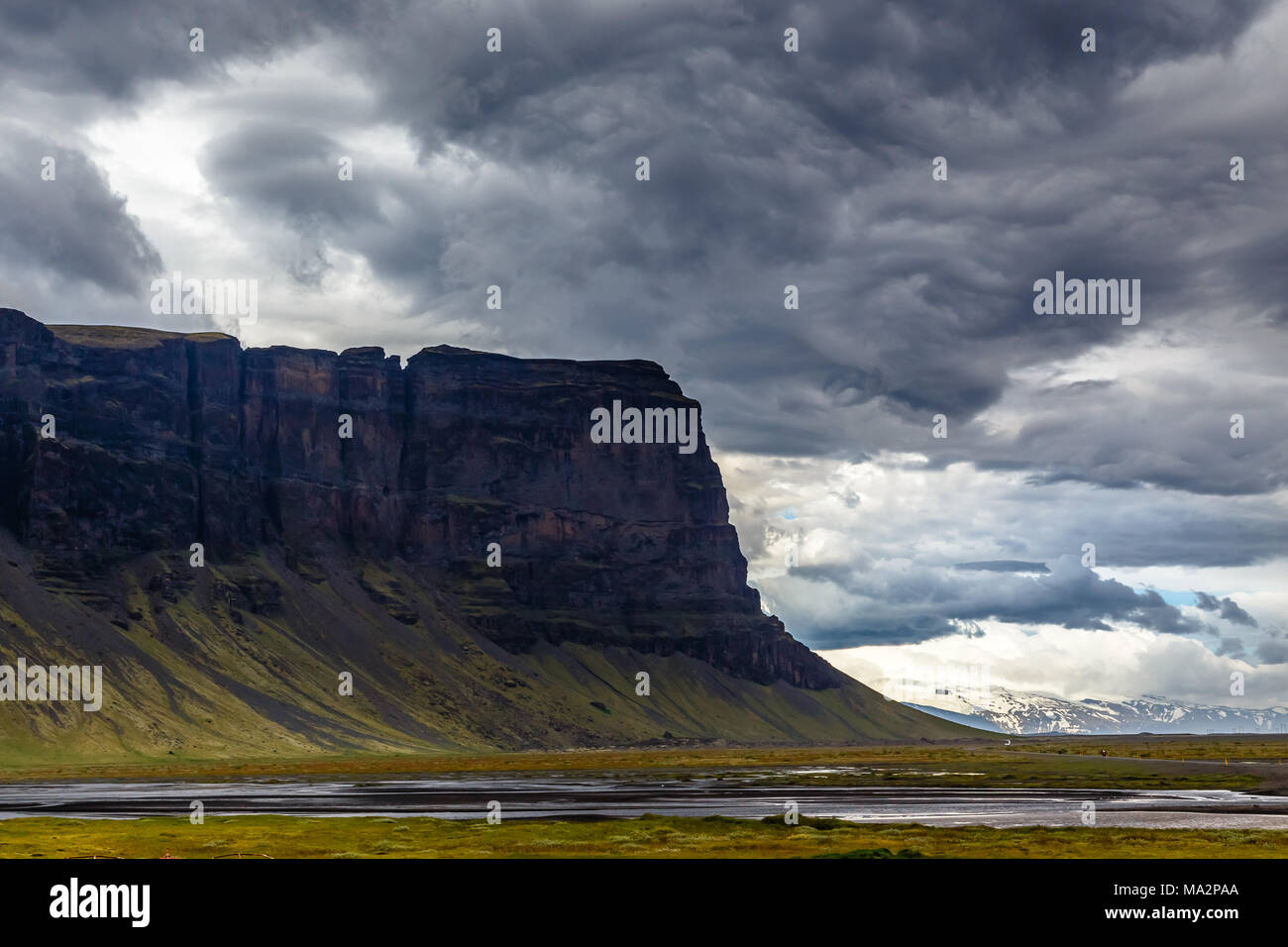 Large steep rock with grey cloud above, near to Kalfafell village ...