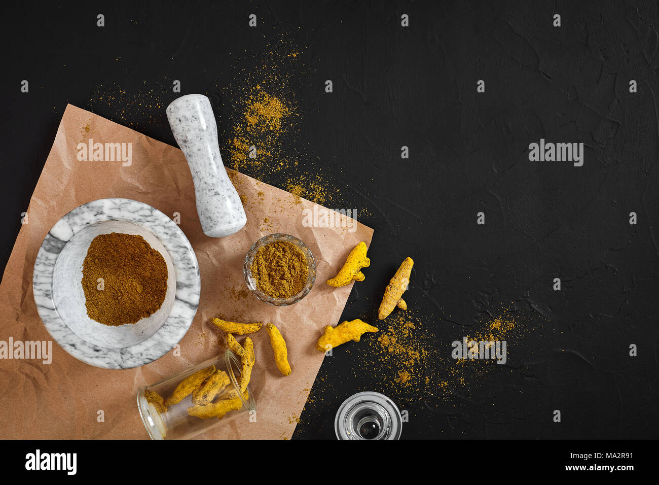 Turmeric Haldi powder in small bowl with raw whole in marble mortar ...