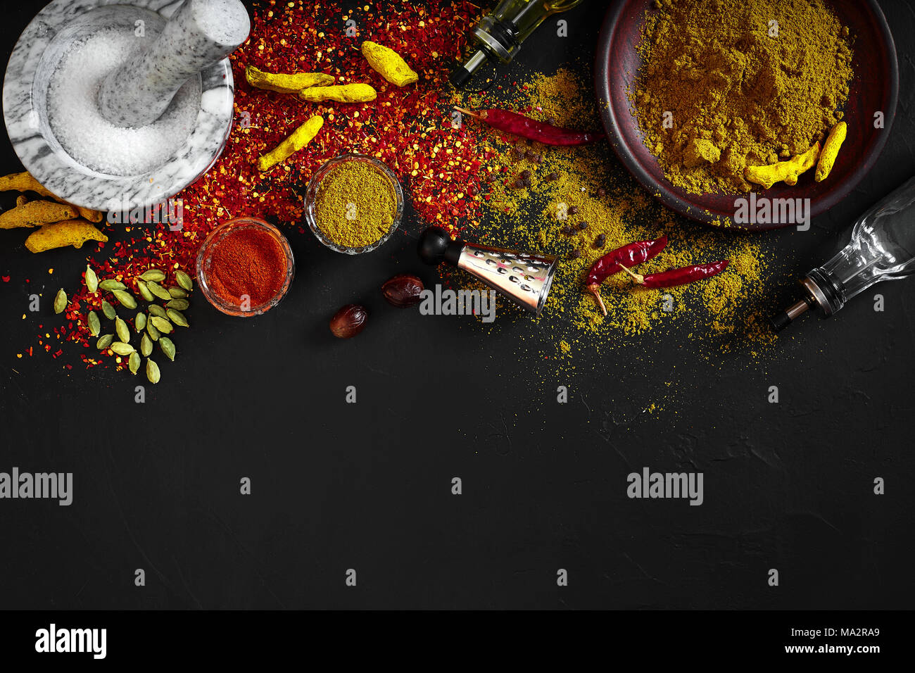 Cooking using fresh ground spices with mortar and small bowls of spice ...