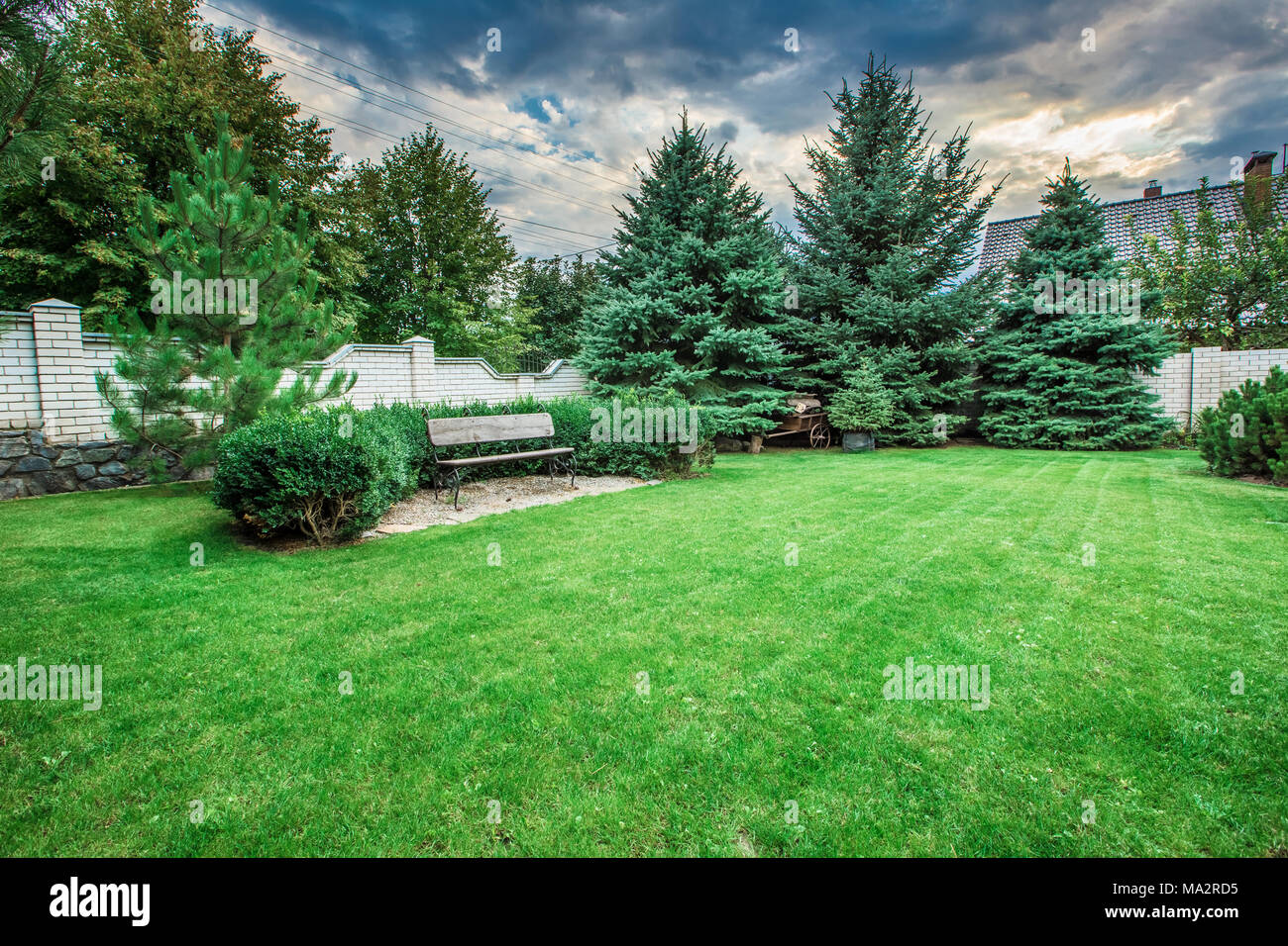 Wooden bench in a beautiful park garden. Summer Stock Photo - Alamy