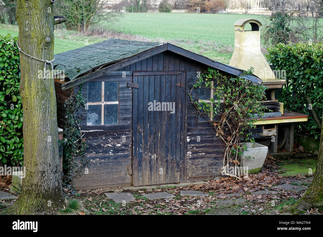 Old desolate barn with dirty vintage window, cute small house on back ...