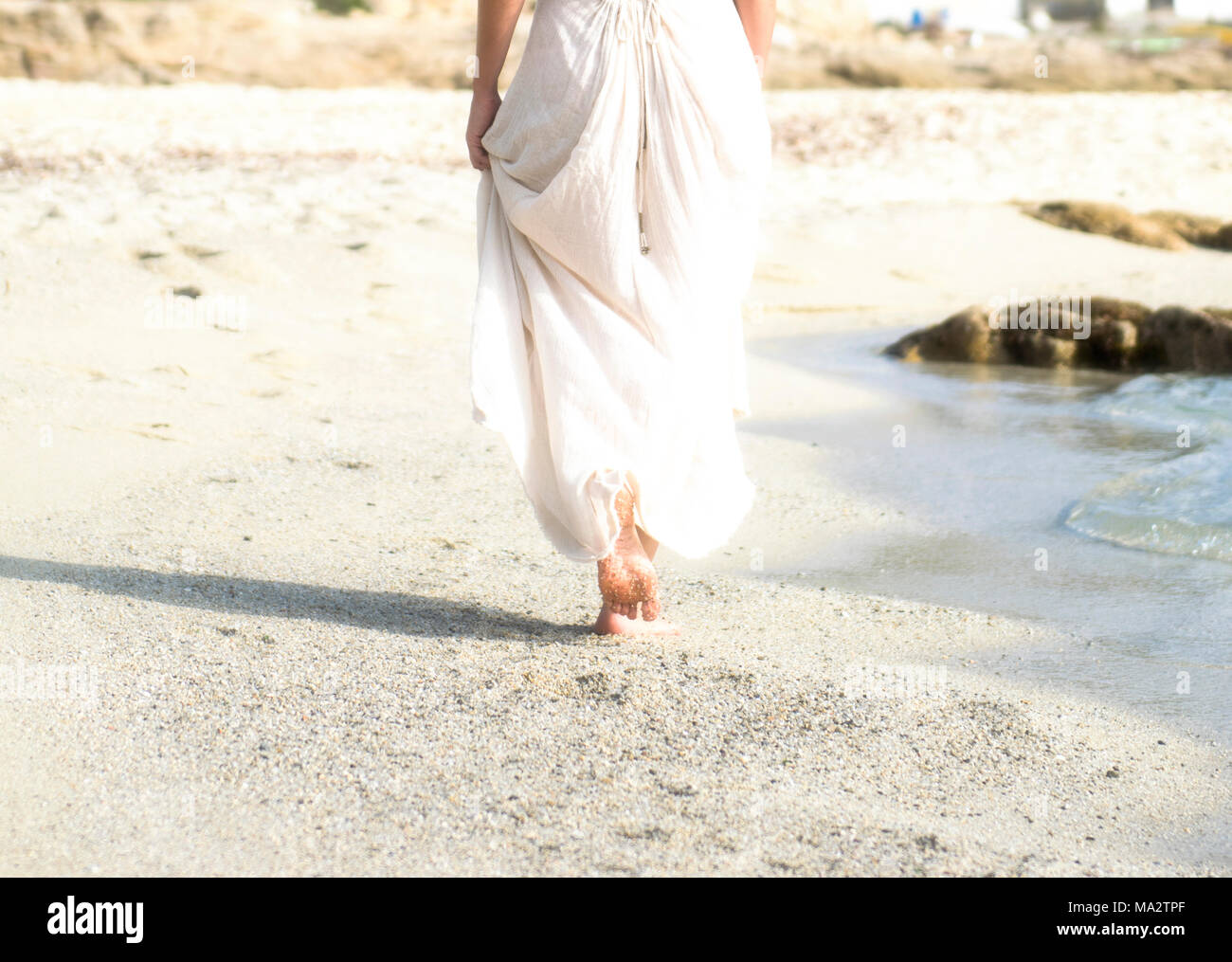 Woman waking alone on the beach Stock Photo - Alamy