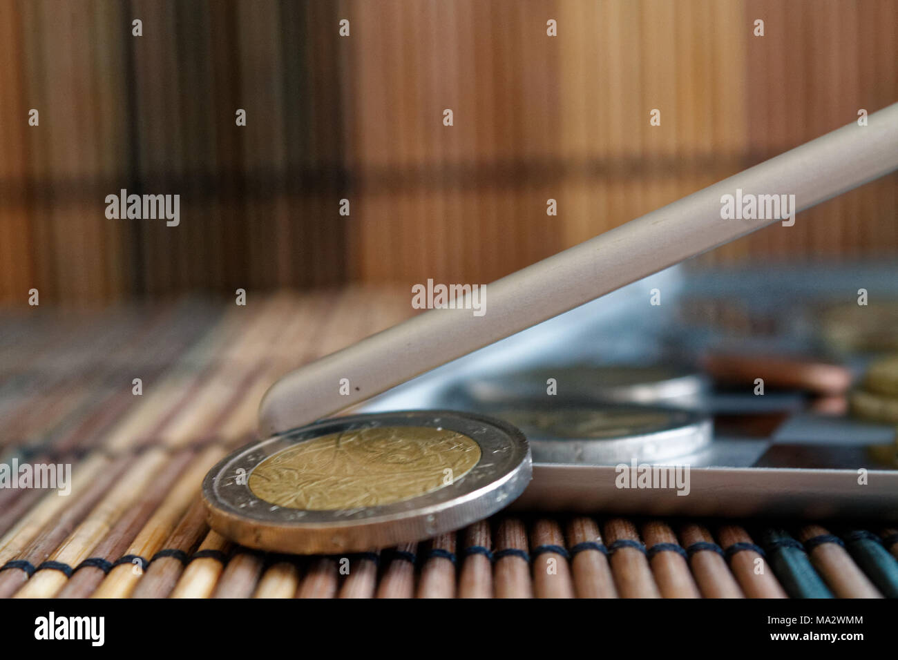 Pile of Euro coins in mirror reflect wallet lies on wooden bamboo table ...