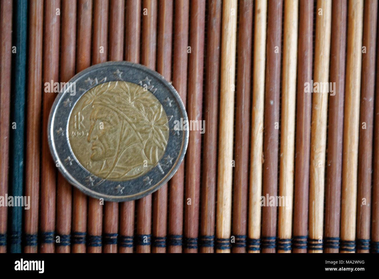 One euro coin lie on wooden bamboo table Denomination is 2 euro - back ...