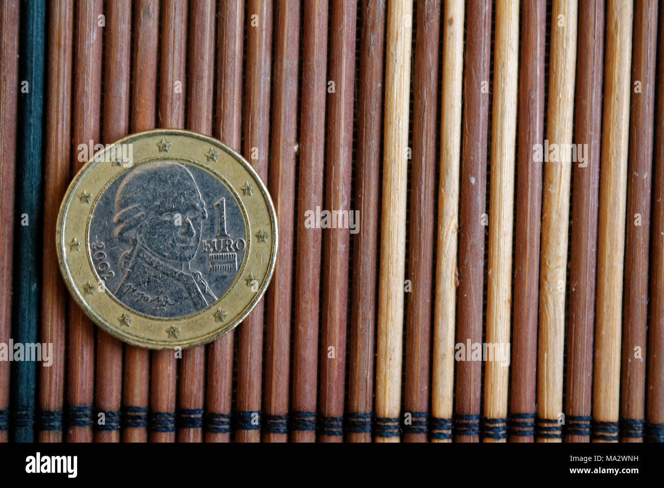 One euro coin lie on wooden bamboo table Denomination is 2 euro - back ...