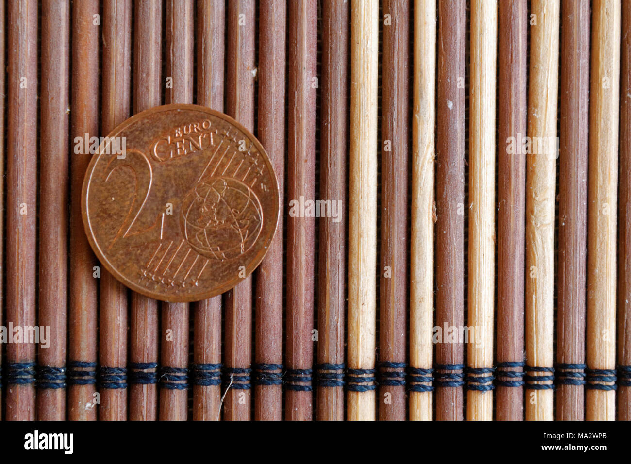 One euro coin lie on wooden bamboo table Denomination is two euro cent ...