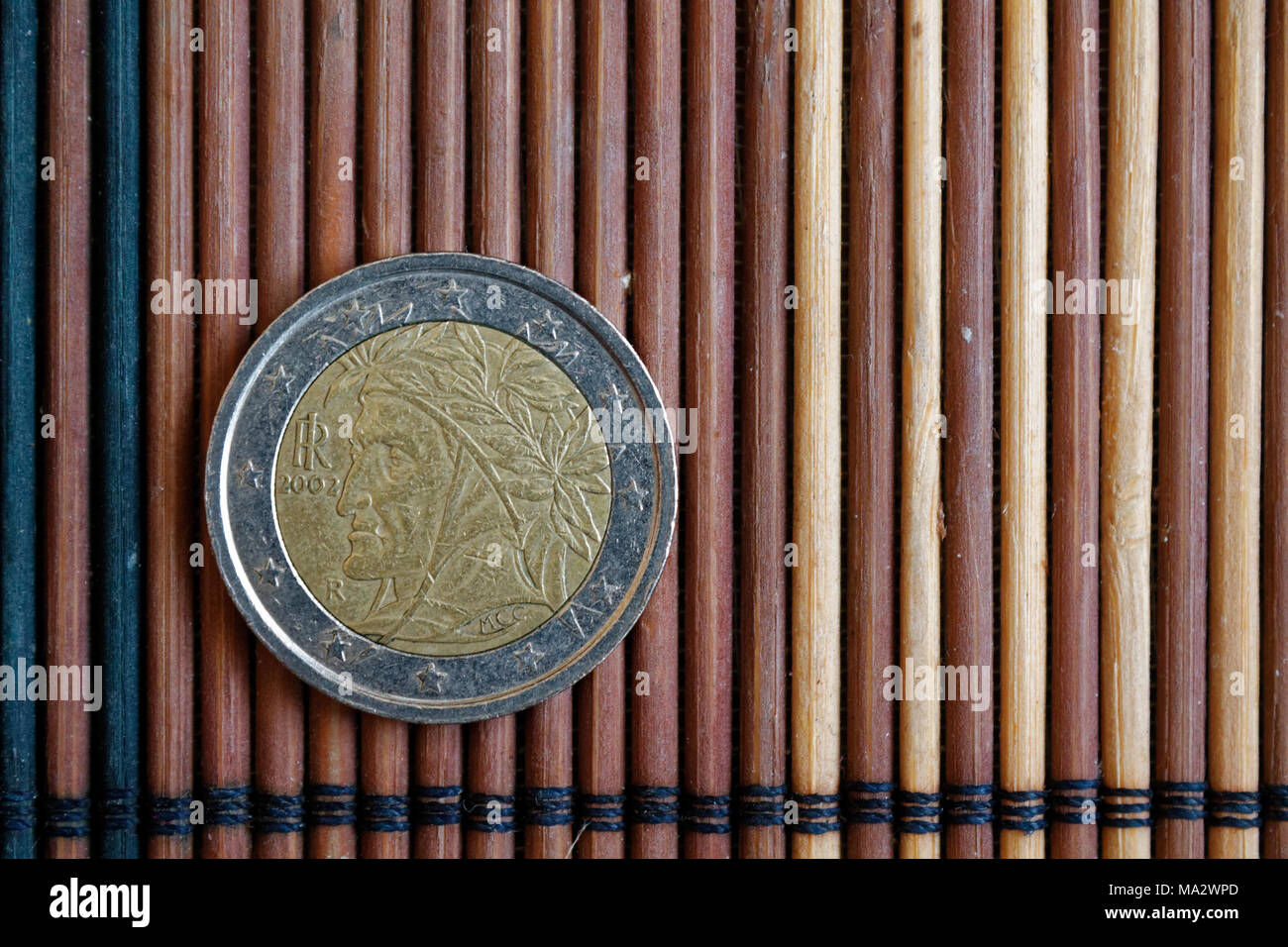 One euro coin lie on wooden bamboo table Denomination is 2 euro back ...
