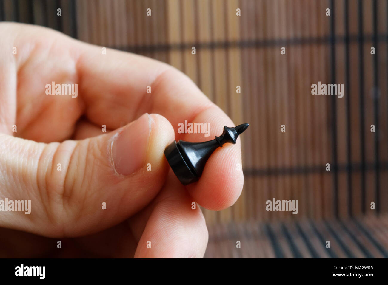 Plastic chess black rook, in man's hand, wooden background Stock Photo ...