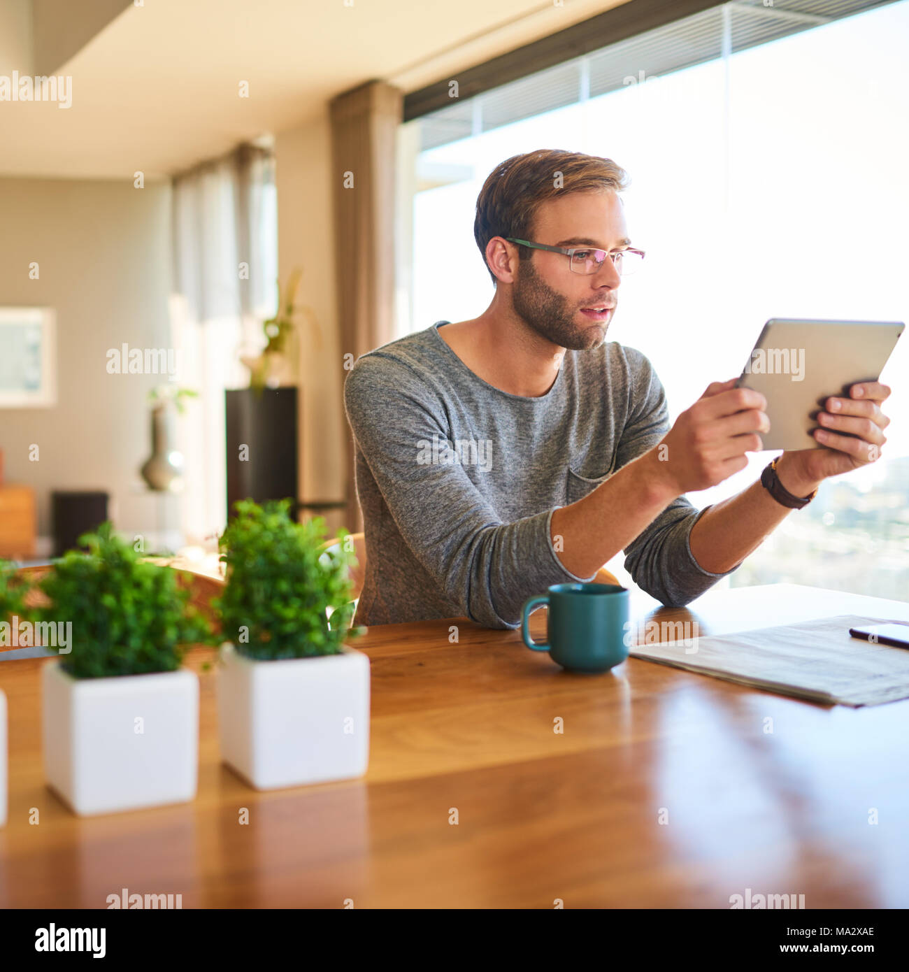 Square image of modern caucasian man sitting at the stunning dining ...