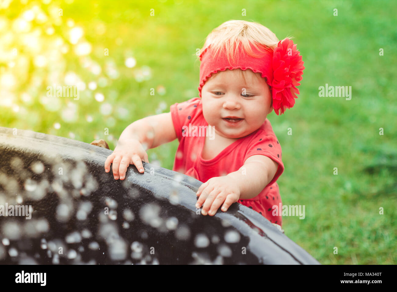 Cute baby girl drinking from water drinking fountain in summer Stock ...