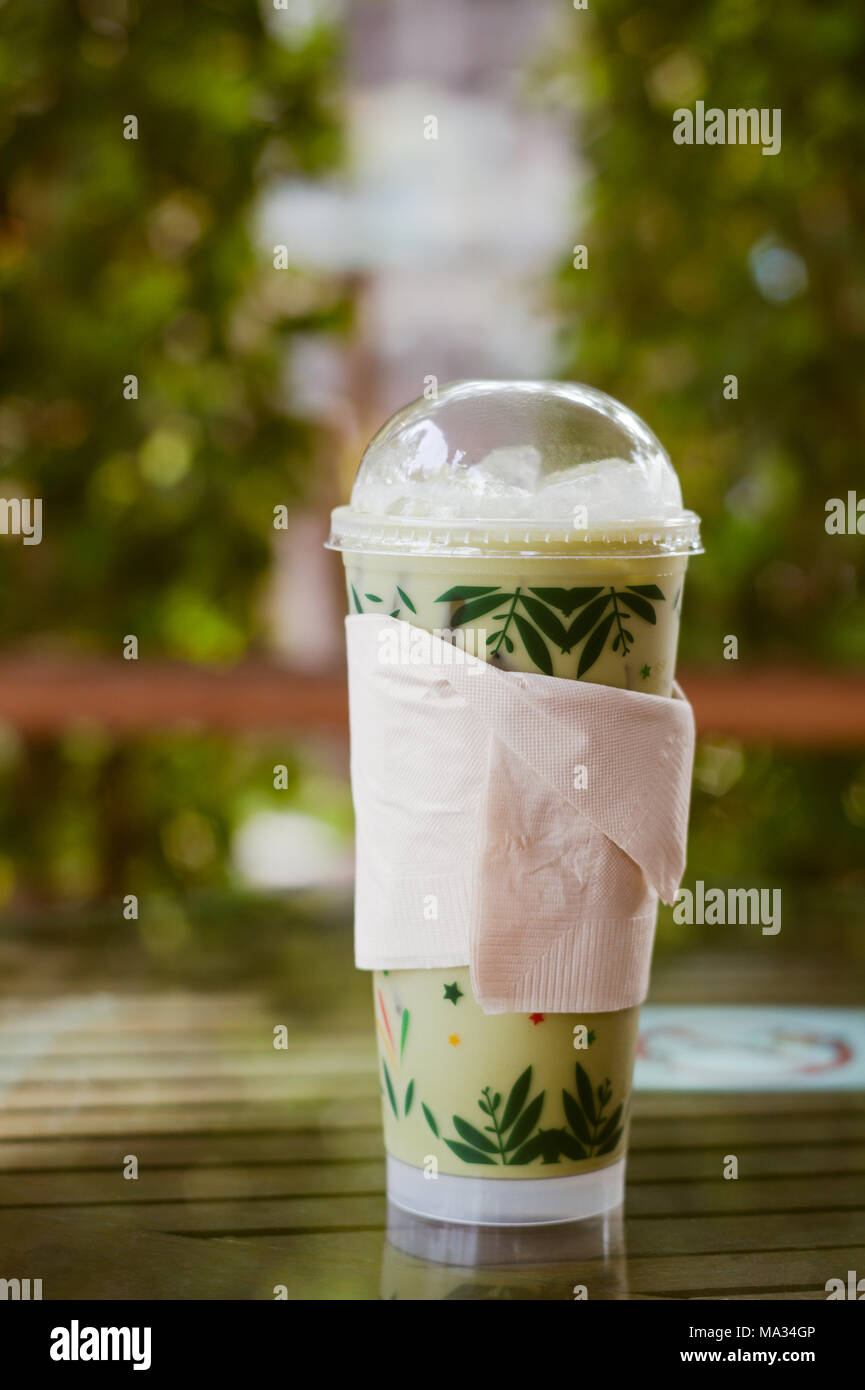 Matcha latte in plastic cup with lid in nature Stock Photo - Alamy