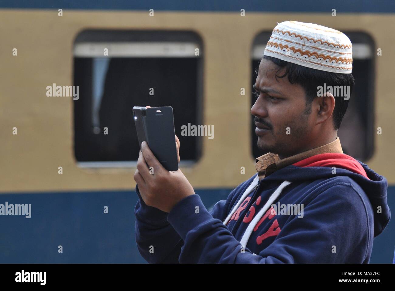 Passenger with mobile phone in the station Tongi near Dhaka on 09.01. ...