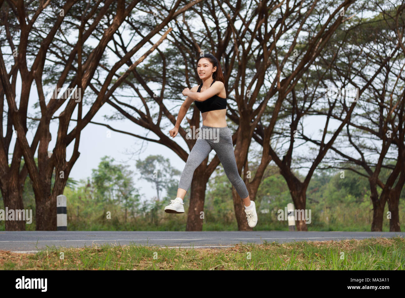 sporty woman running and jumping in the park Stock Photo - Alamy
